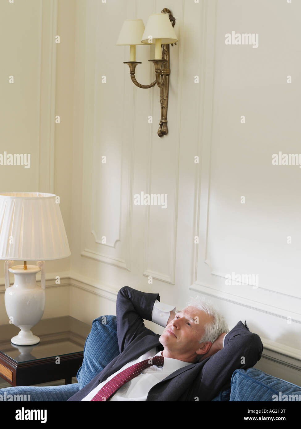 Business man leaning back on sofa, elevated view Stock Photo - Alamy