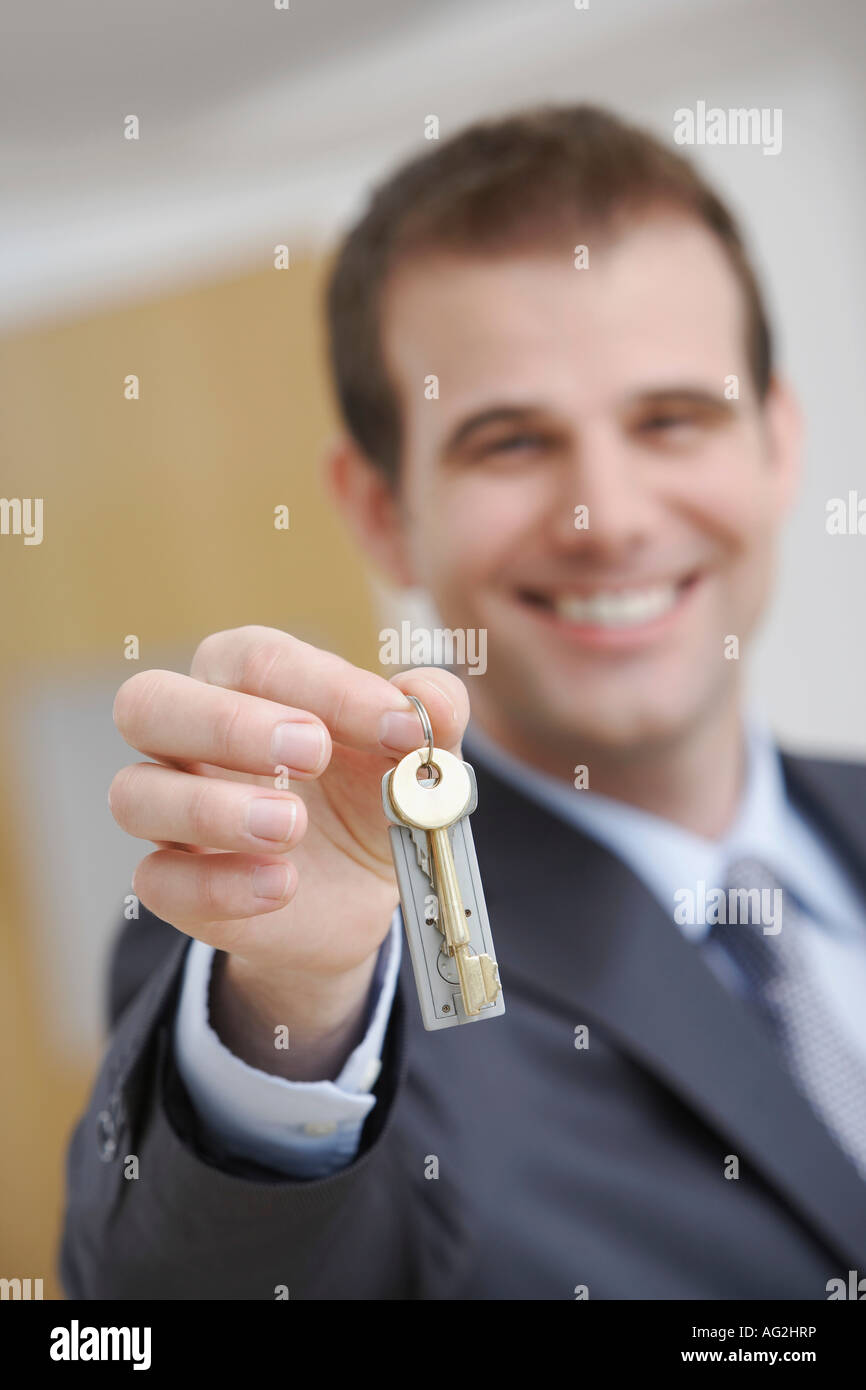 Real estate agent holding key, indoors Stock Photo - Alamy