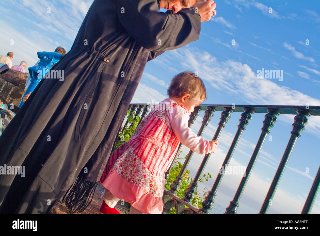 Little girl playing and holding onto metal handrail at viewpoint Stock ...