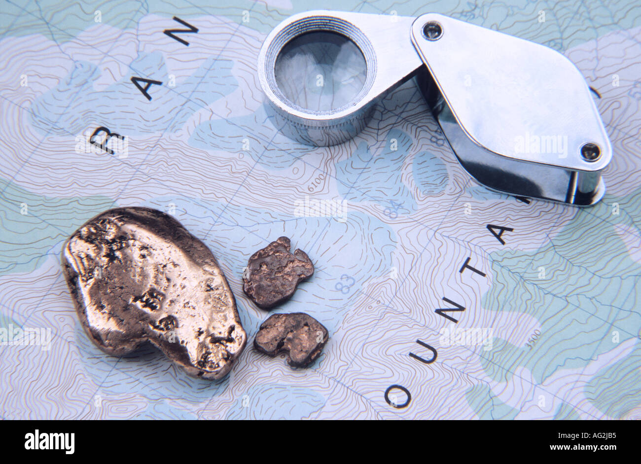 Mining concept image of map magnifier and nuggets Stock Photo - Alamy