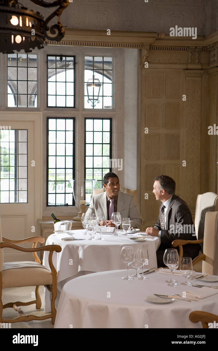 Two business men sitting at restaurant table talking Stock Photo - Alamy
