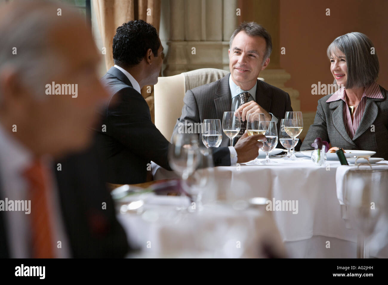 Three business people sitting at restaurant table, talking Stock Photo ...