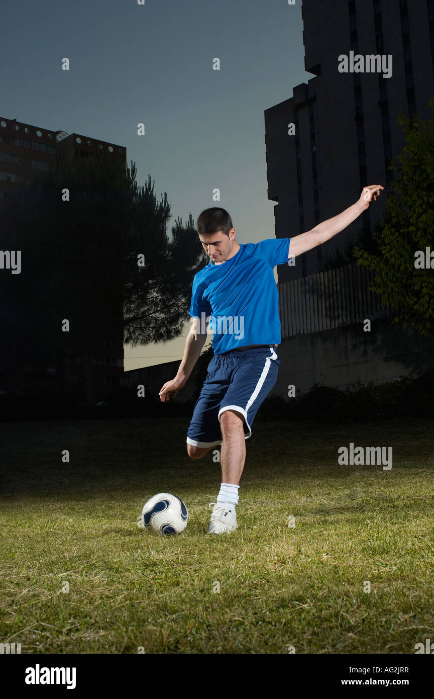 Young man playing football Stock Photo - Alamy