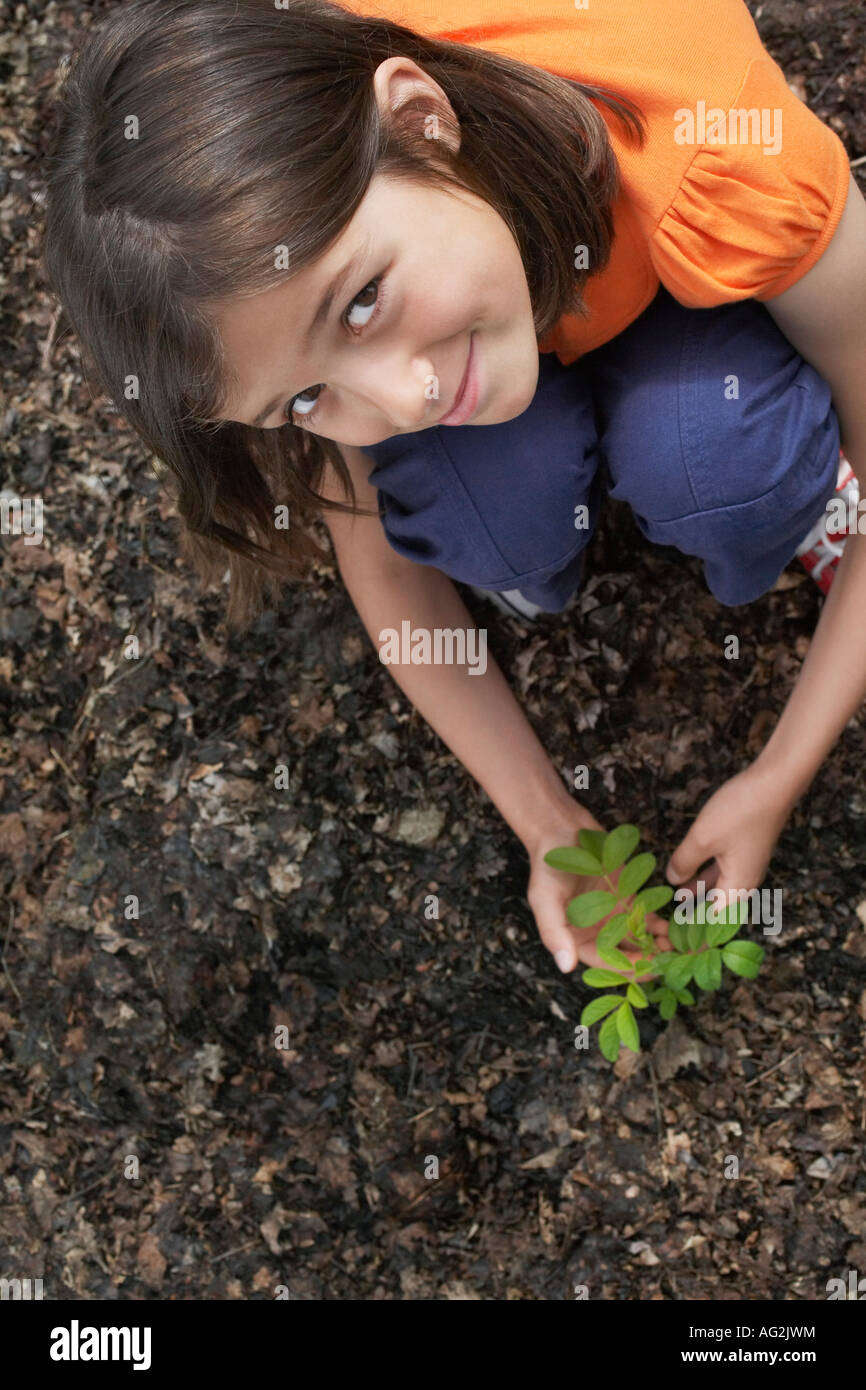Portrait of girl (7-9) planting black locust tree Stock Photo - Alamy
