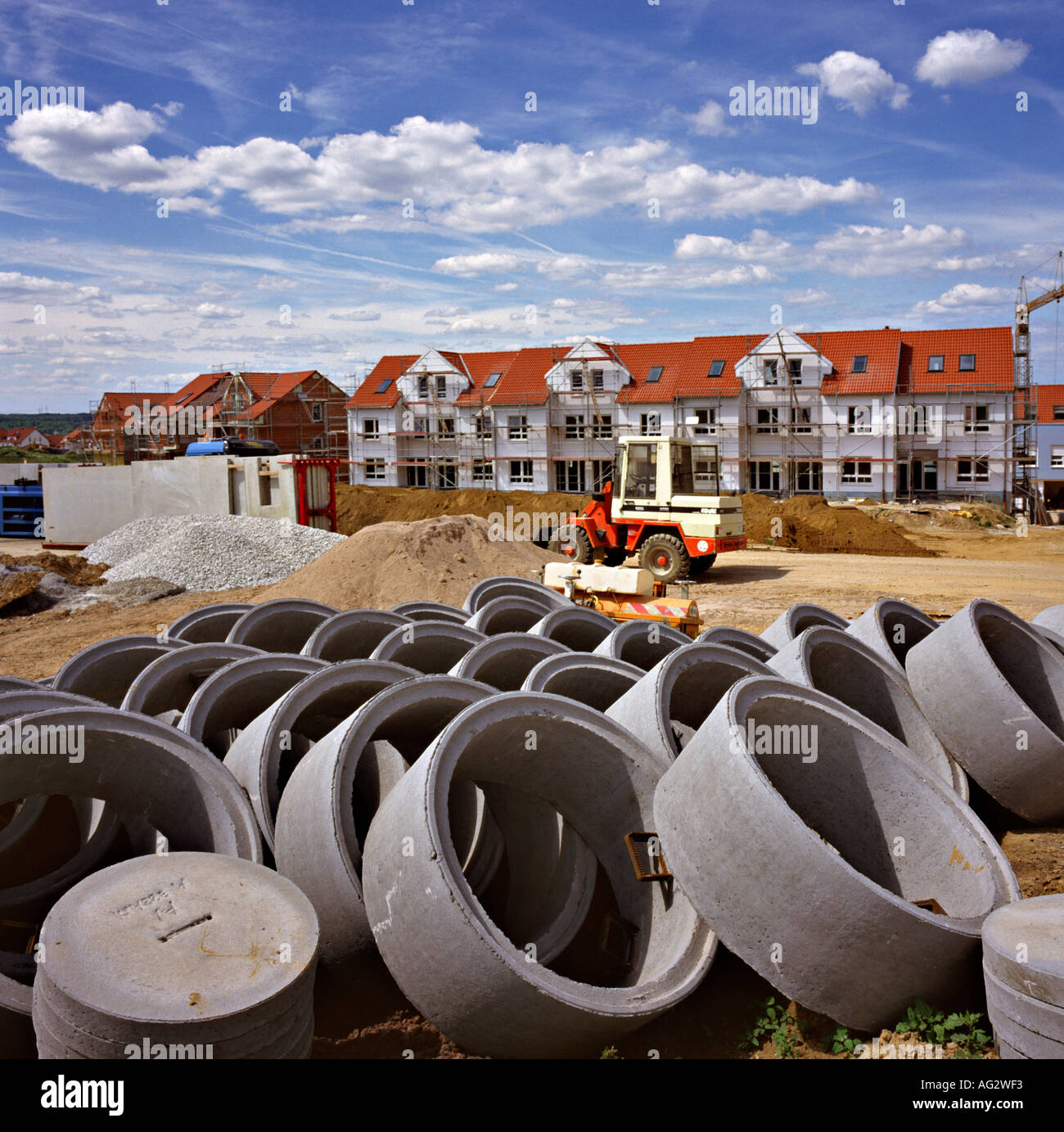 concrete sewer pipes manhole rings on a building site for homes with ...