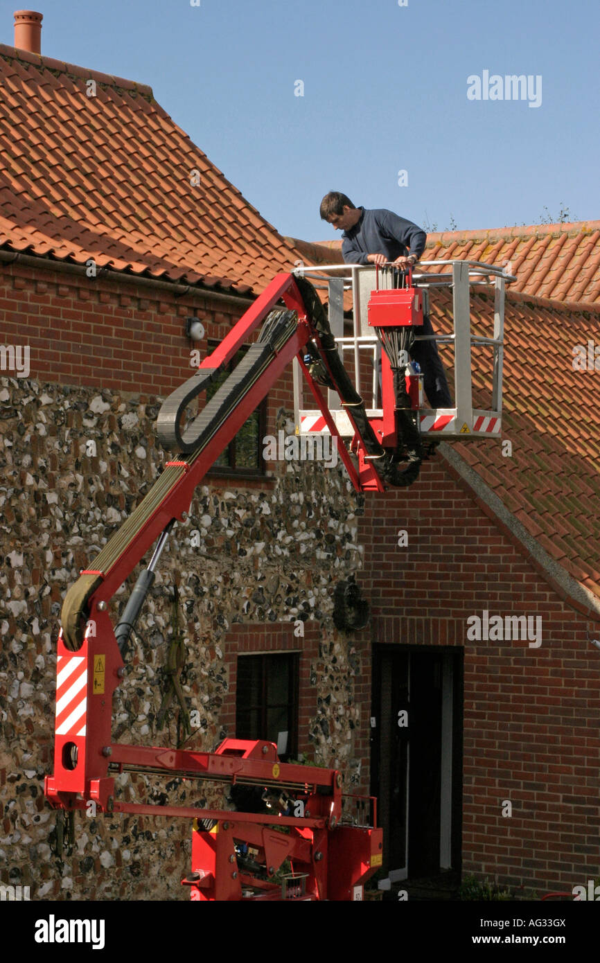 A Workman operating a cherry picker machine Stock Photo - Alamy