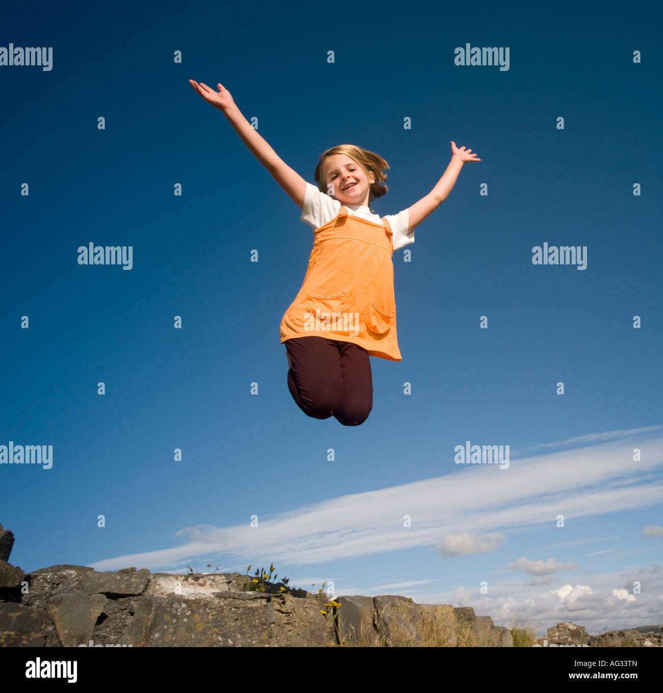 young 8 year old female child leaping in the air with joy fun ...