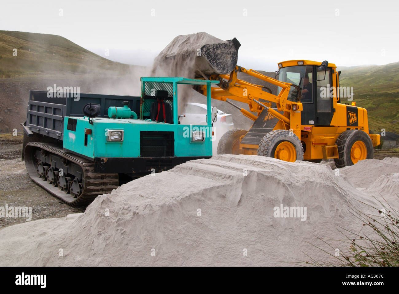 Loading a tracked vehicle with lime on a remote mountain road to the ...