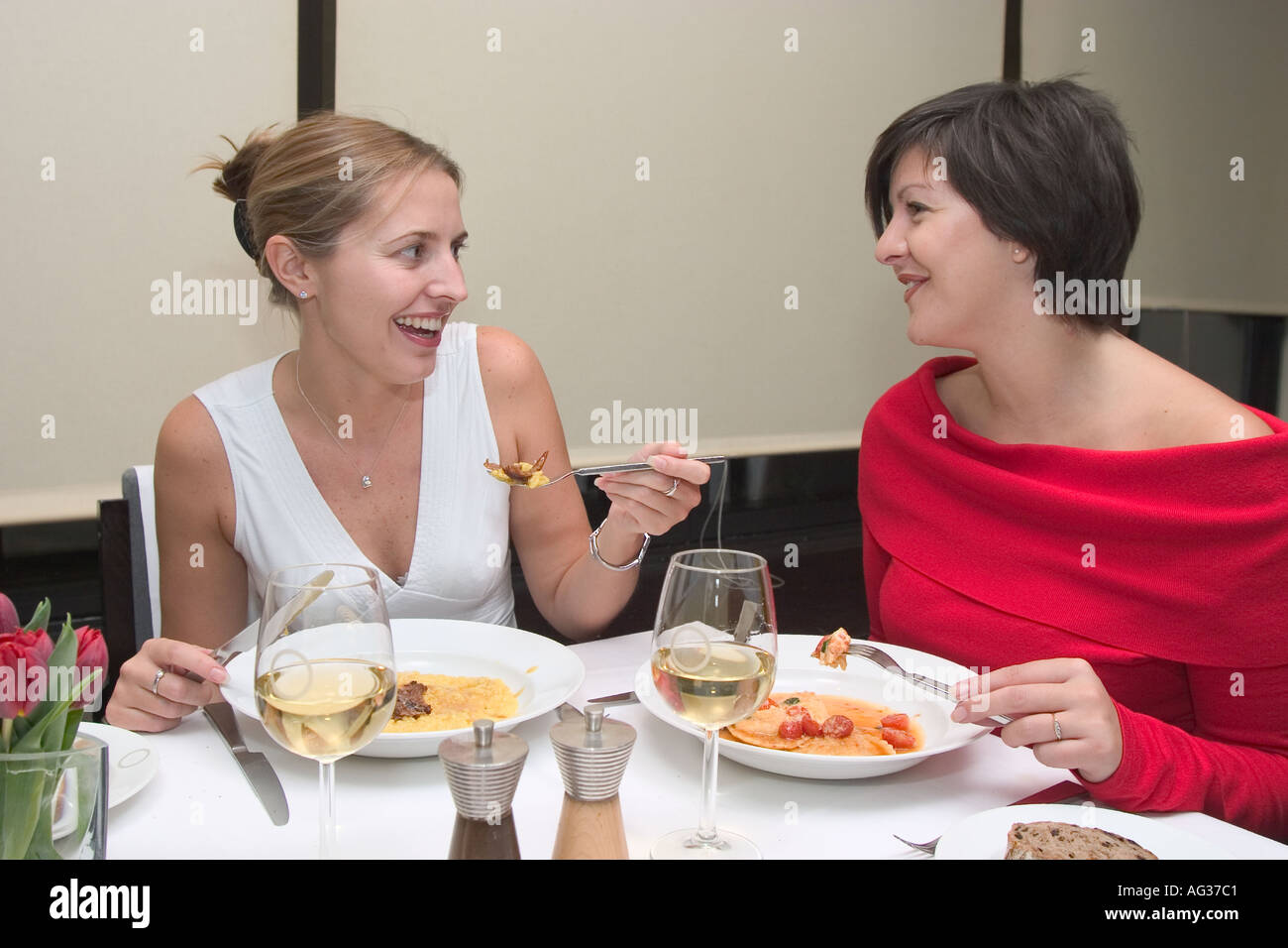 Two young women talking over dinner in a restaurant Stock Photo - Alamy