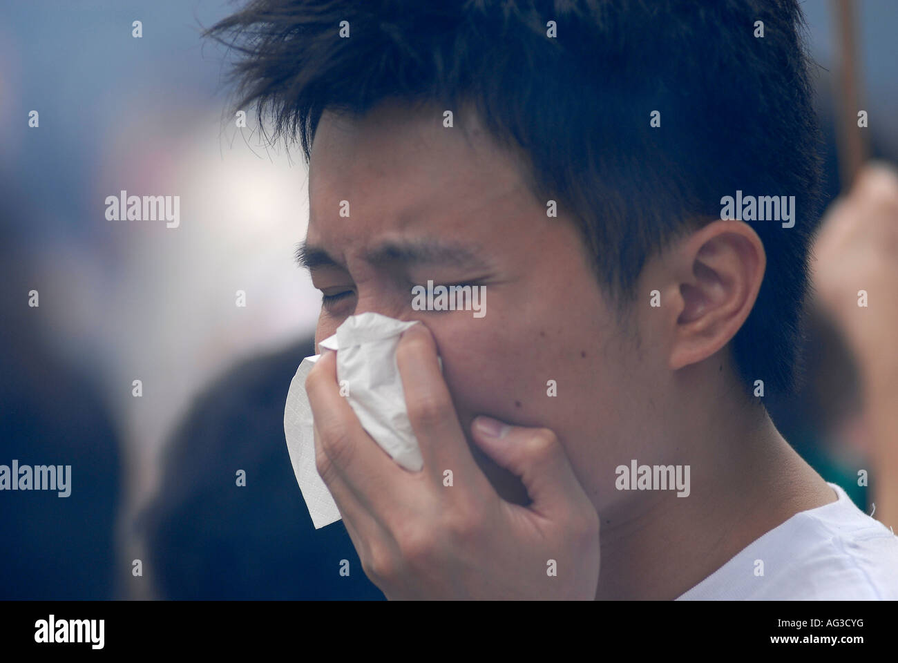 Young Chinese man covering his mouth with handkerchief China Stock ...