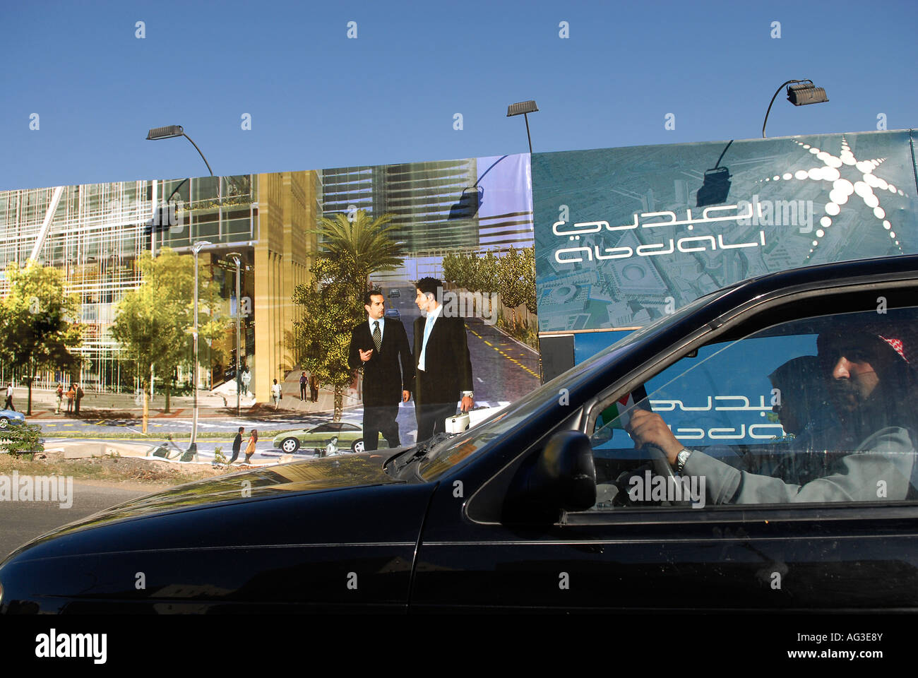 Jordanian man wearing a Kafiyah driving a car drives by billboard ...