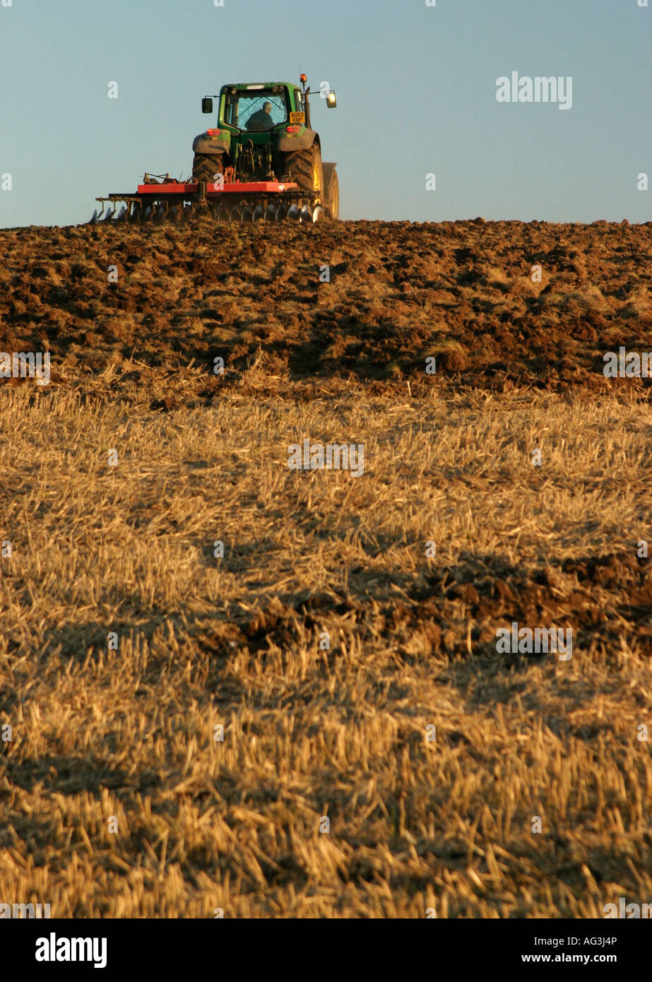 A tractor cultivating a field Stock Photo - Alamy
