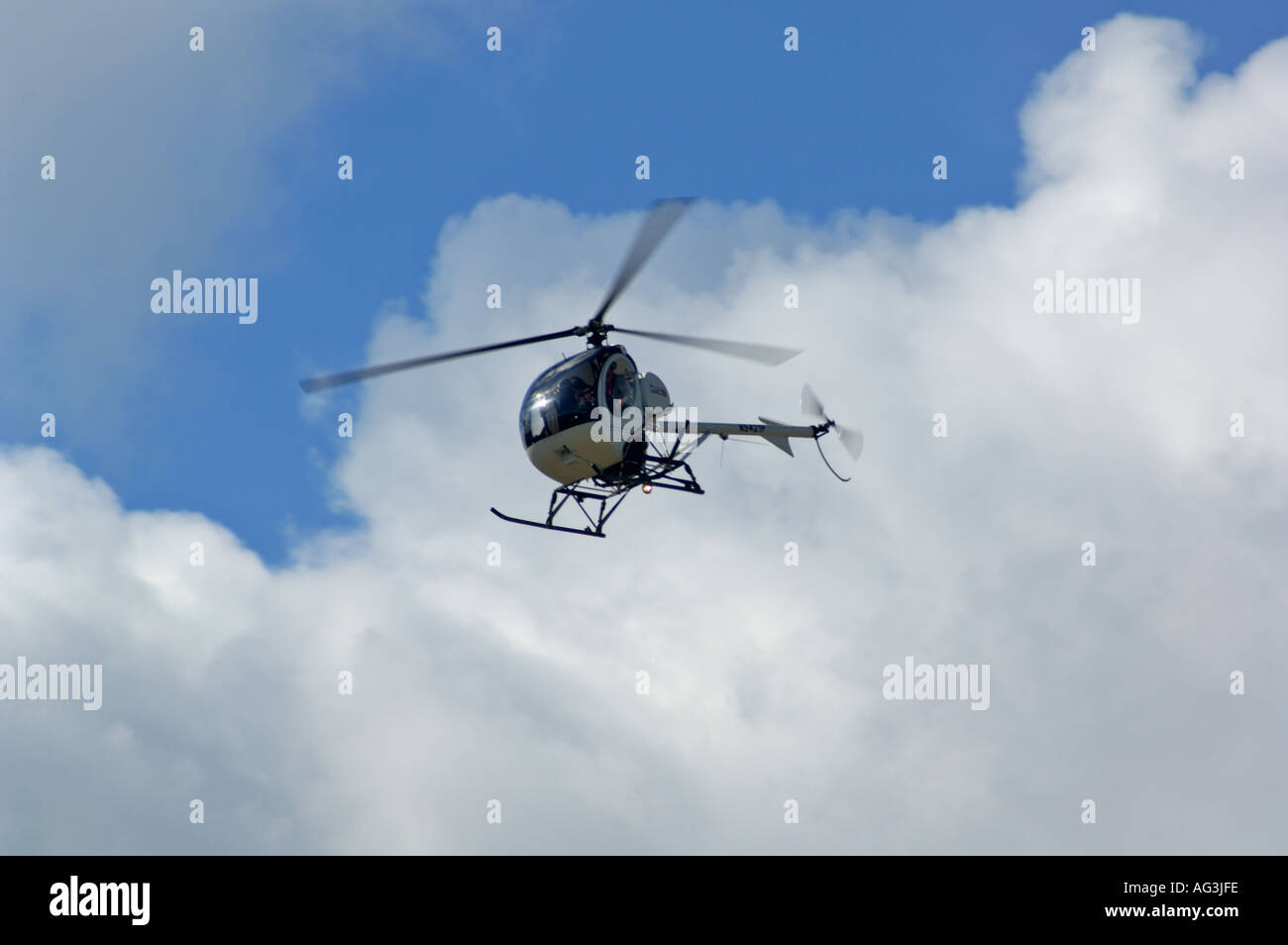 Small SCHWEIZER 269c 1 rotorcraft helicopter flying in blue sky and ...
