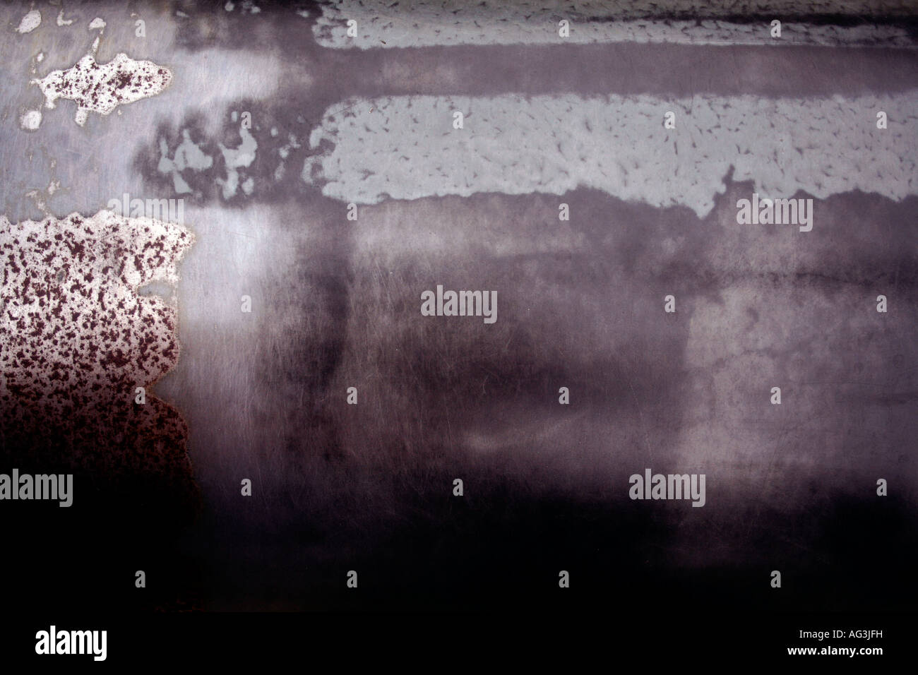 Brushed steel surface with patches of red rust dark and light fades ...