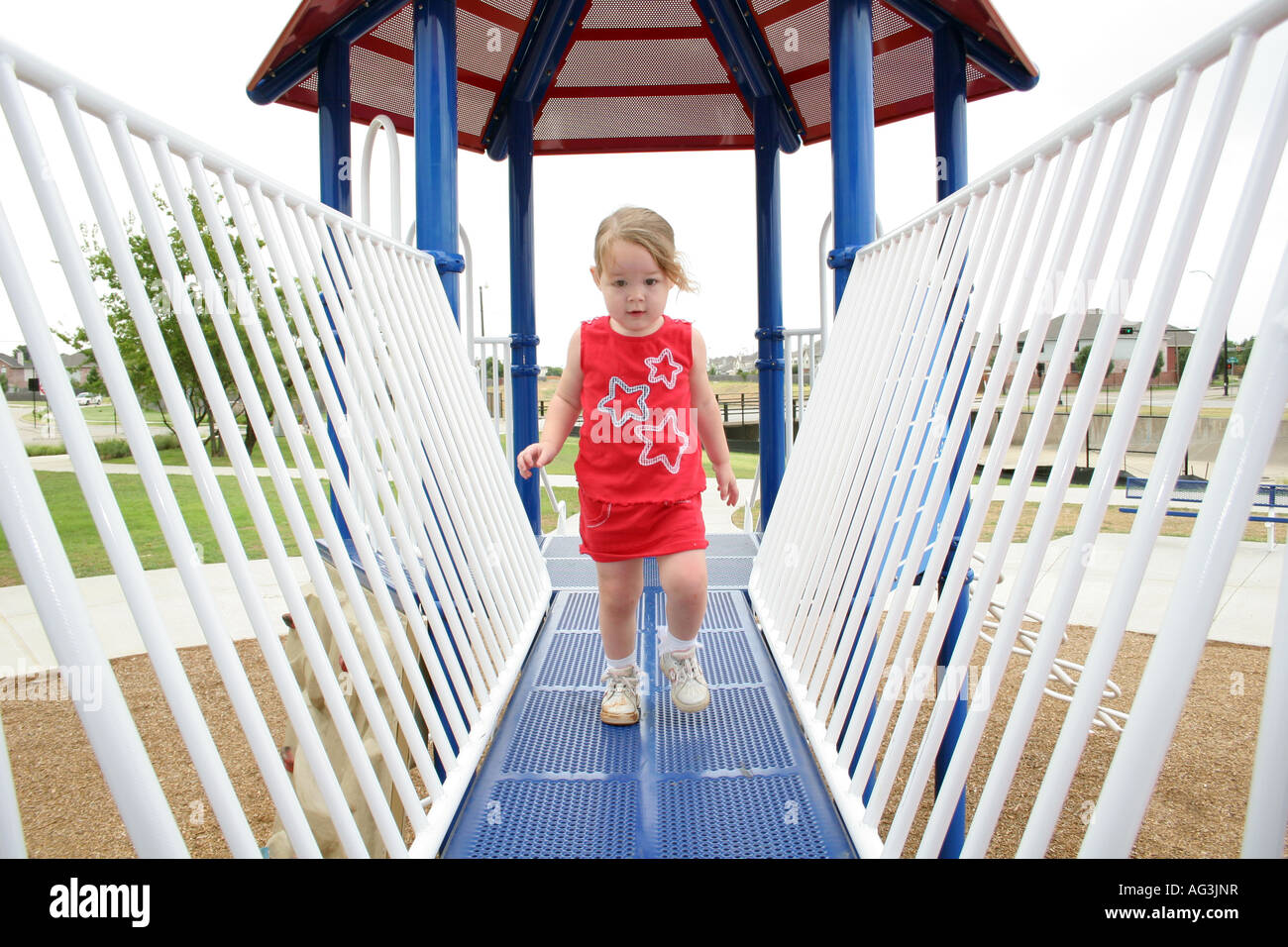 Young girl walking over playground walkway Stock Photo - Alamy