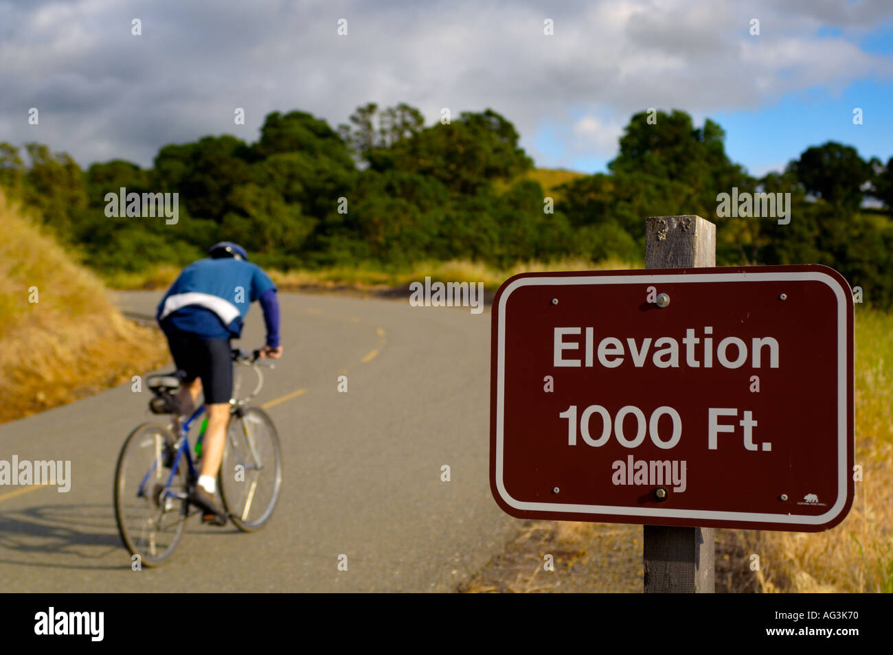 Person going up hill on a bike hi-res stock photography and images - Alamy