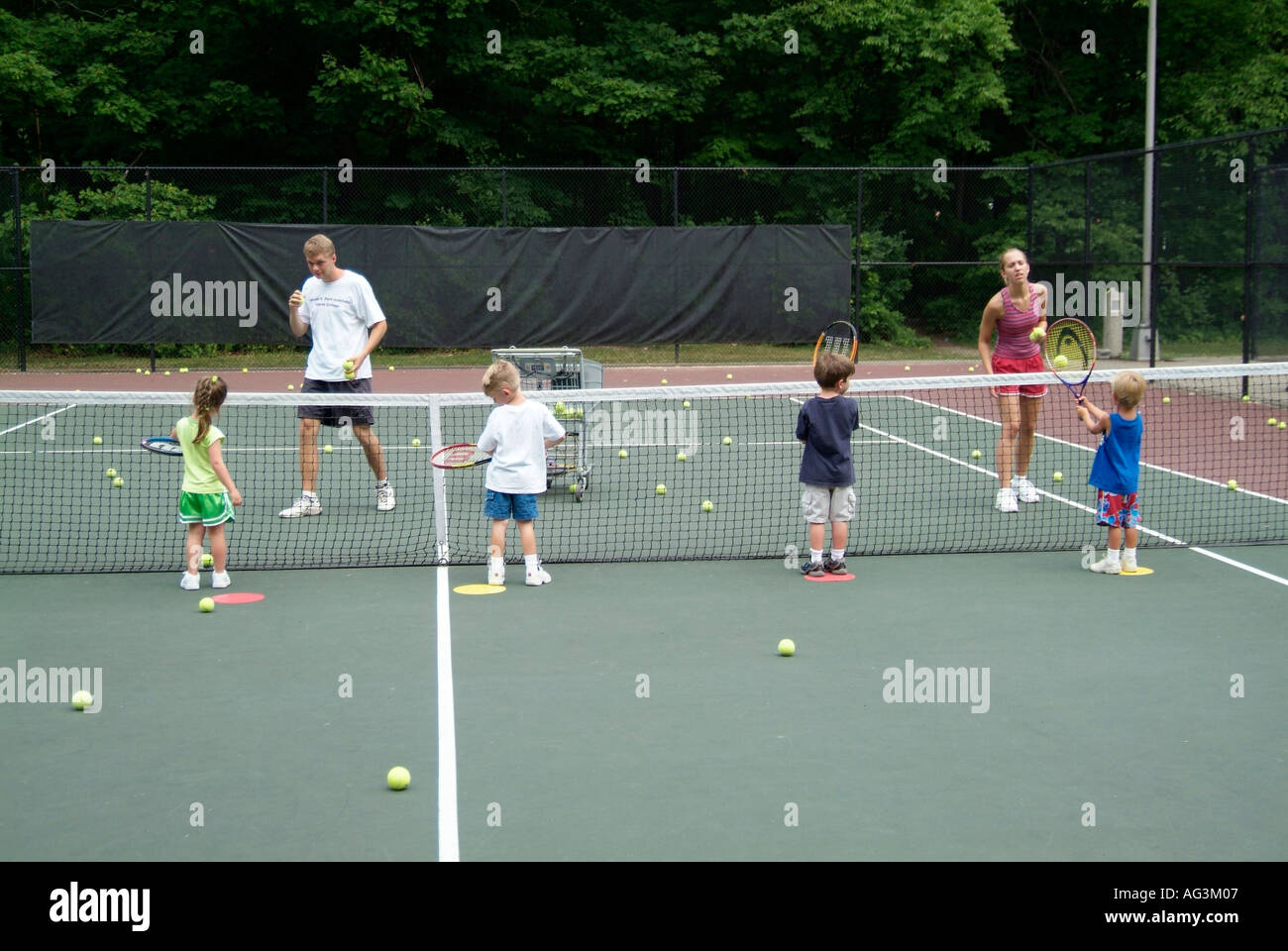 4 and 5 year old children take group tennis lessons taught by college ...