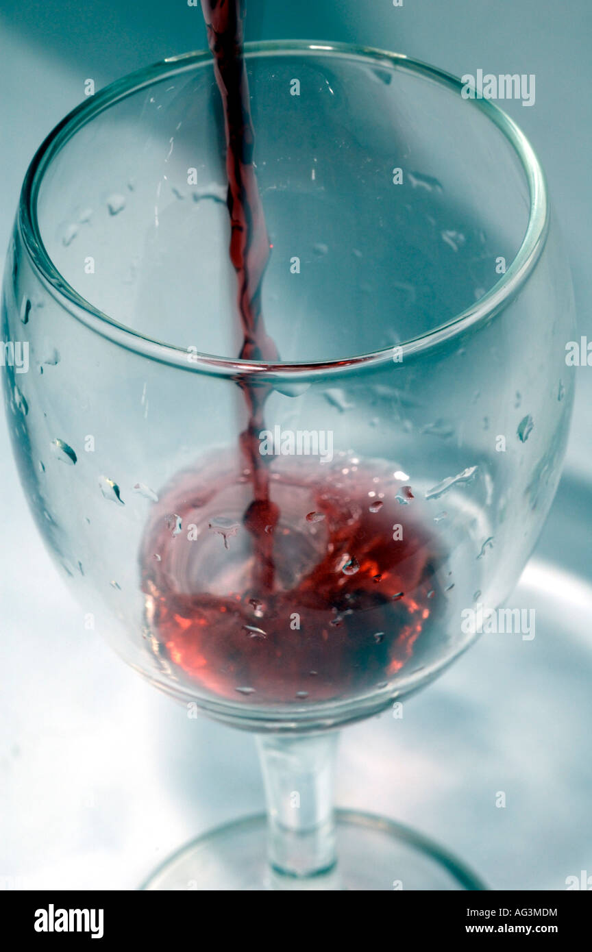 Red wine flowing into wine glass Stock Photo - Alamy
