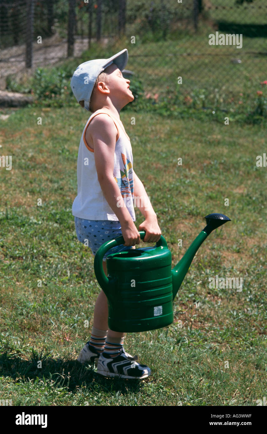 Boy carrying watering can hi-res stock photography and images - Alamy