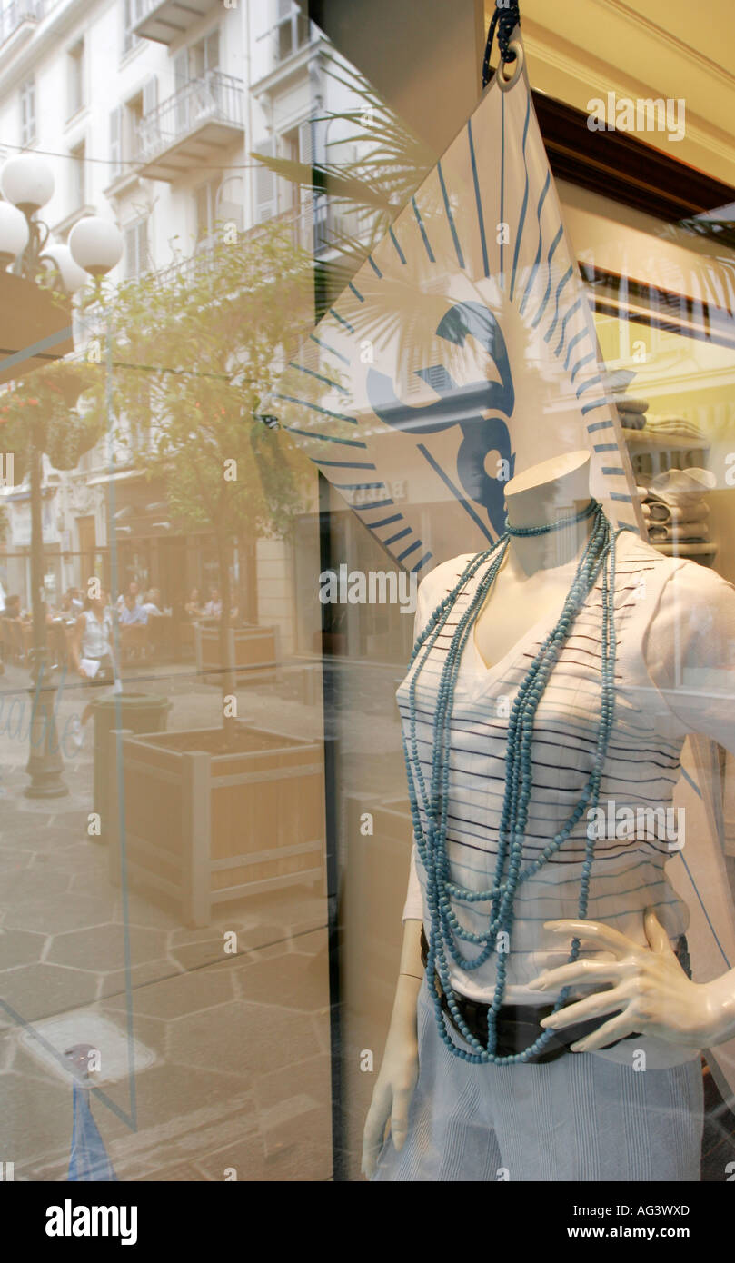 Headless mannequin in a shop window dressed in white with strings of ...