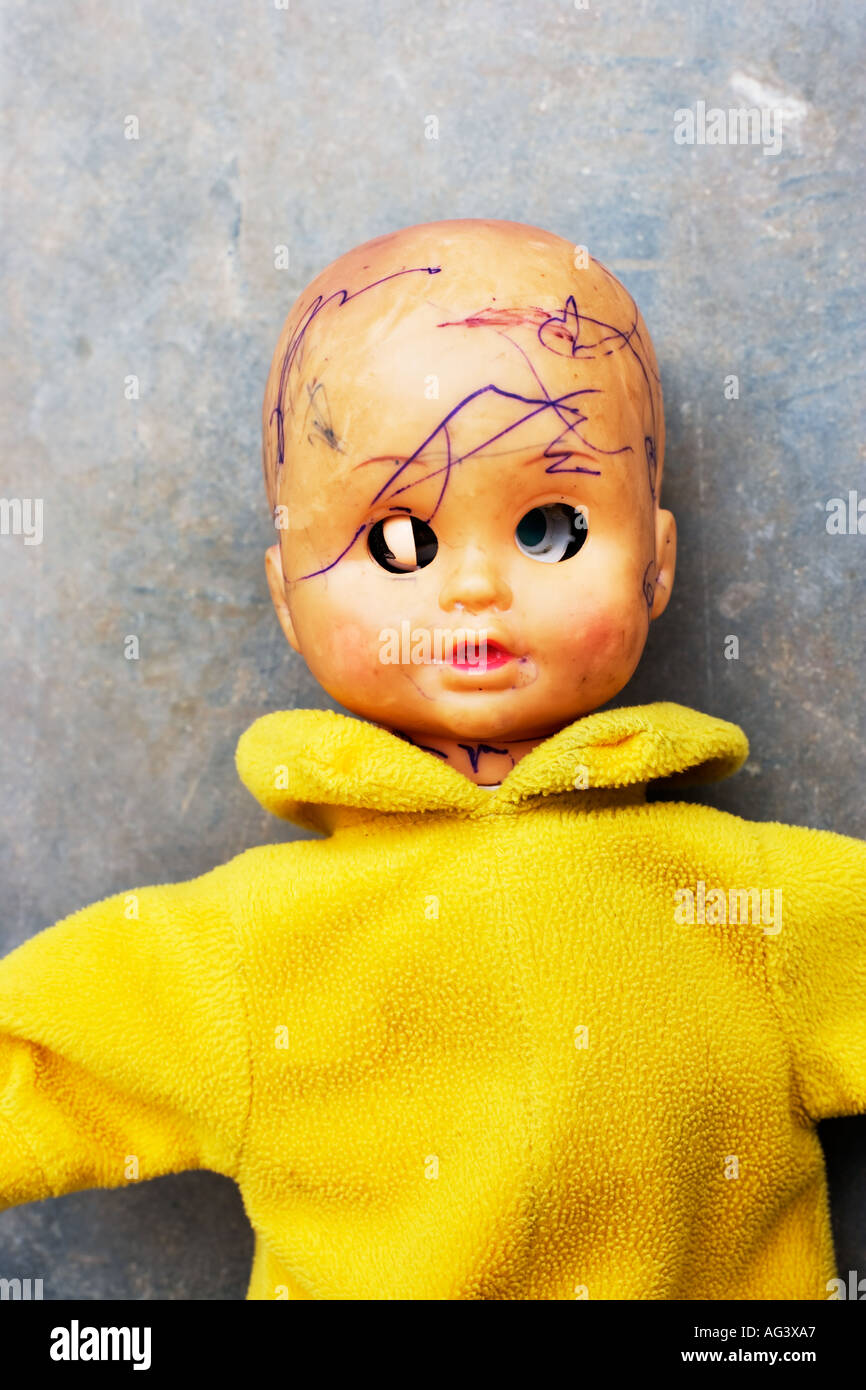 Toy doll with bright yellow top discarded by a child and abandoned on a ...