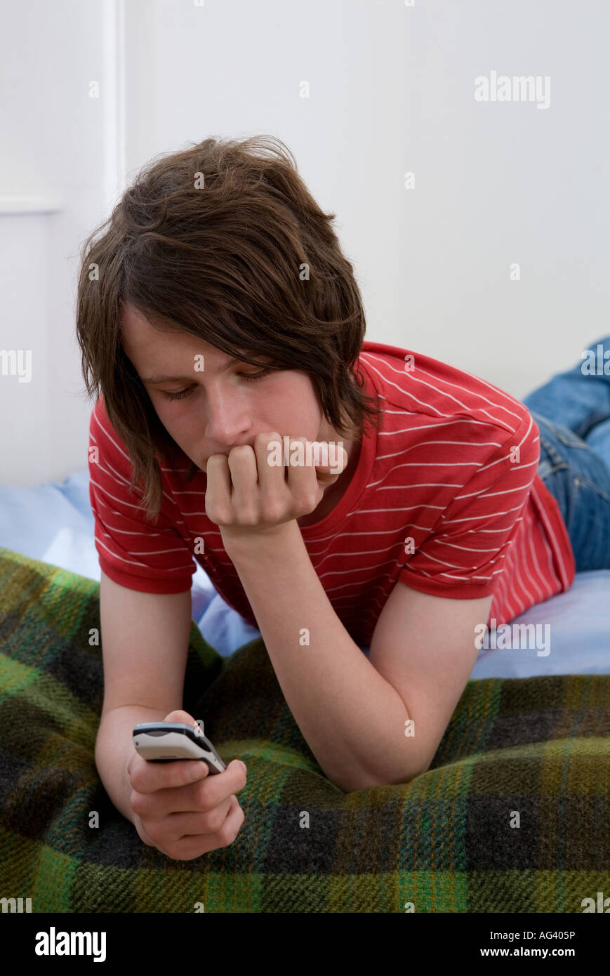 Teenage boy using cell phone Stock Photo - Alamy