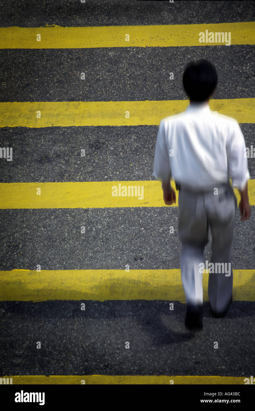 Man crosses the street at the pedestrian crossing area Stock Photo - Alamy
