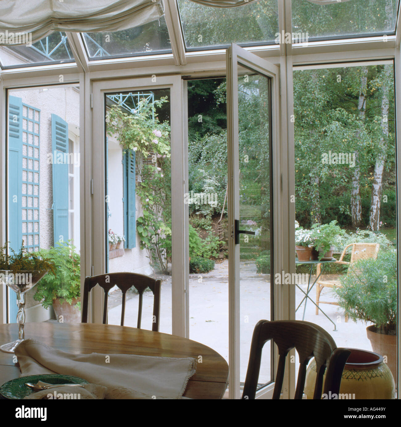 Glass French doors in conservatory dining room with view of patio ...