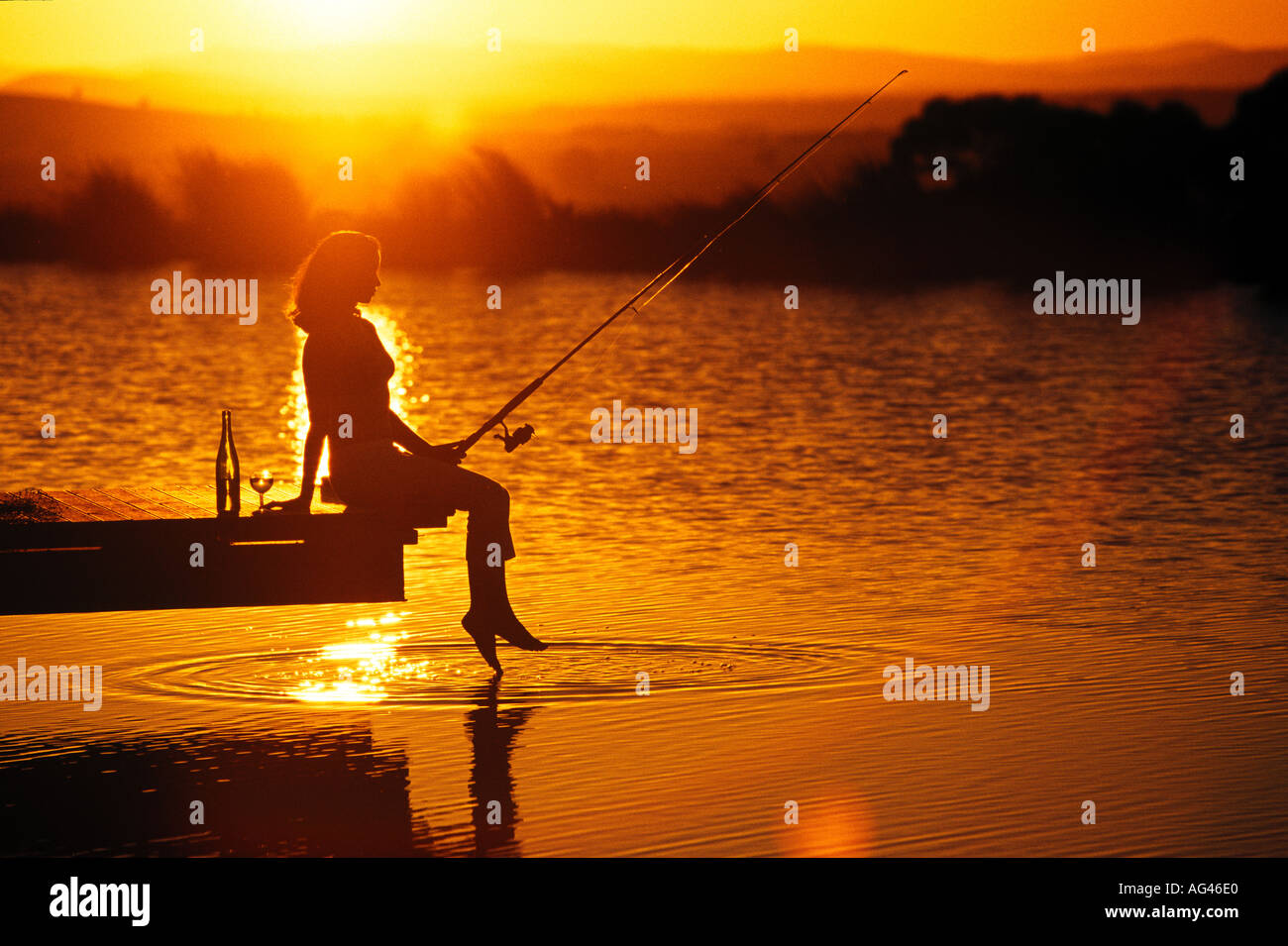 Girl fishing at sunset mood lifestyle shot with wine Model released 287 ...