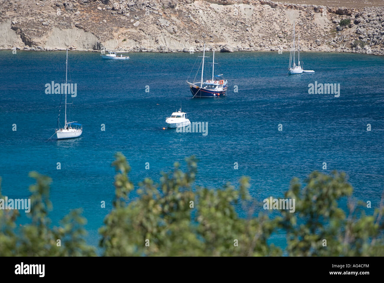 Boats moored in the natural harbour at Lindos on the Greek island of ...