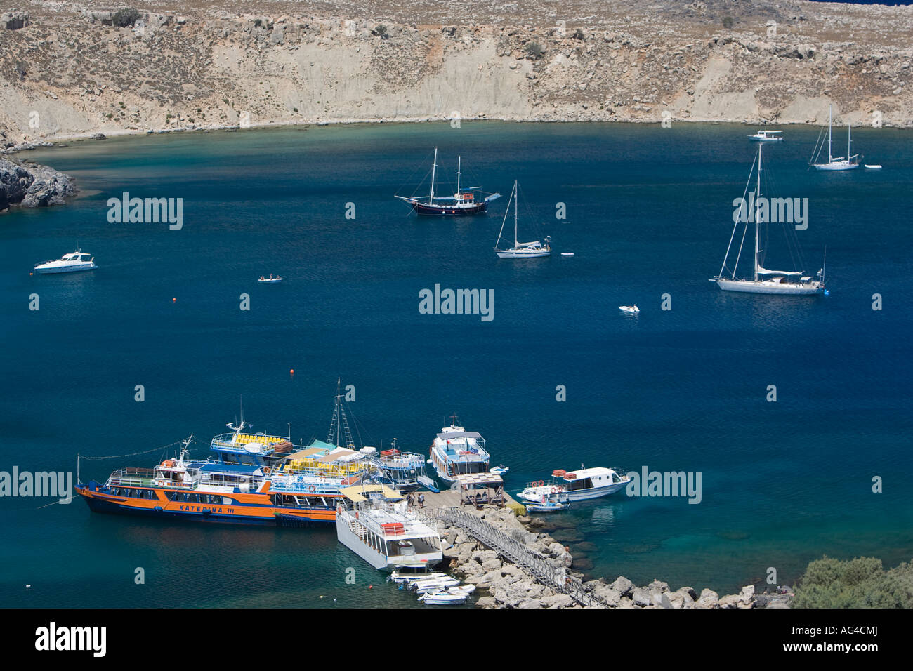 Boats and ferries mooring at Lindos Bay on the Greek island of Rhodes ...