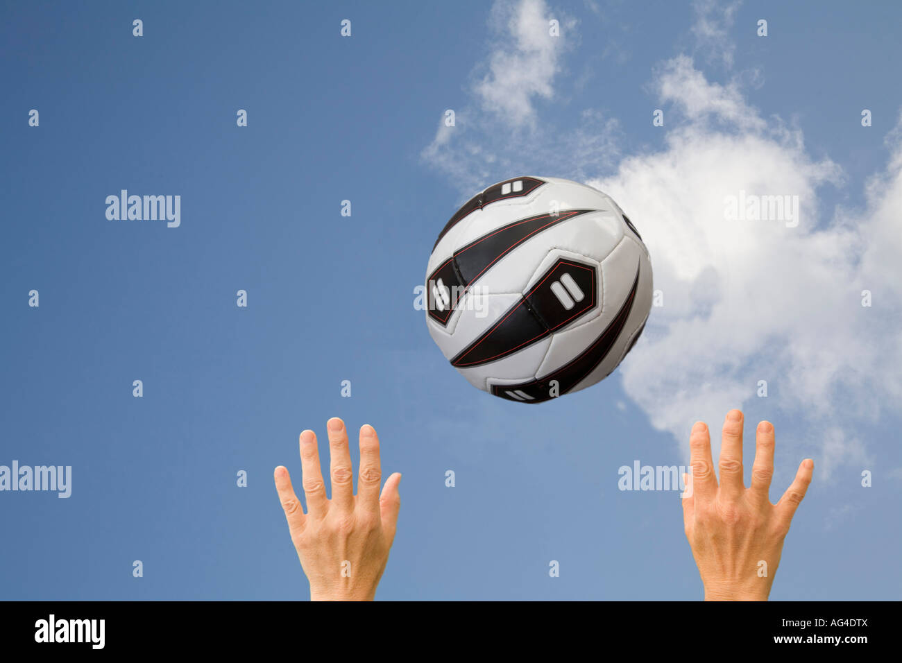 STUDIO Two hands reaching up to a netball in a blue sky Stock Photo - Alamy