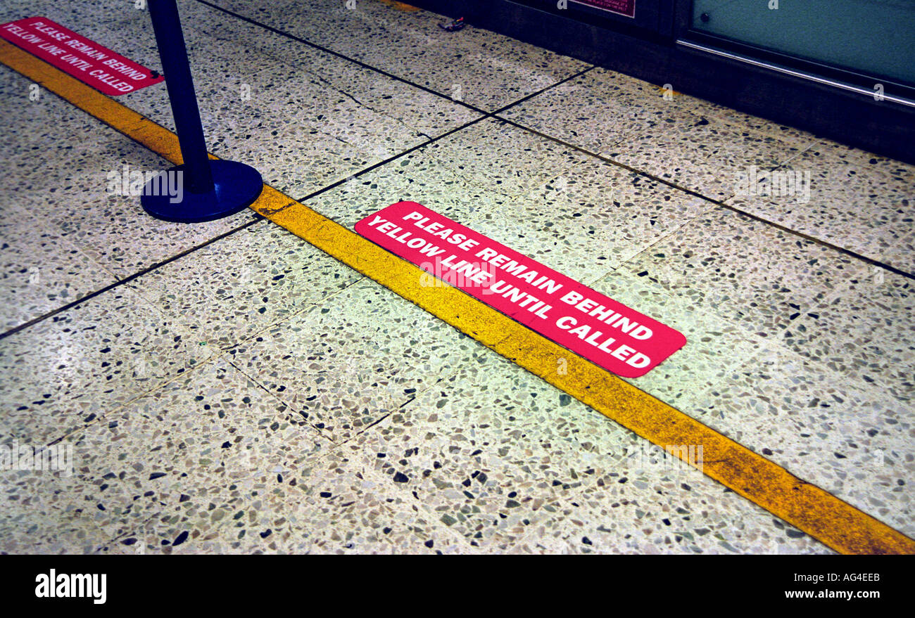 Wait behind line sign at an Airport Stock Photo - Alamy