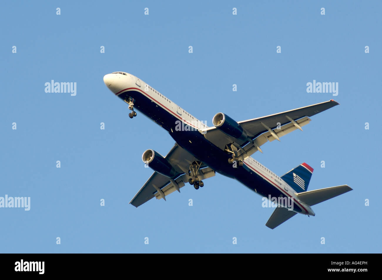 A Boeing 757 with landing gear down flying in a clear sky Stock Photo ...