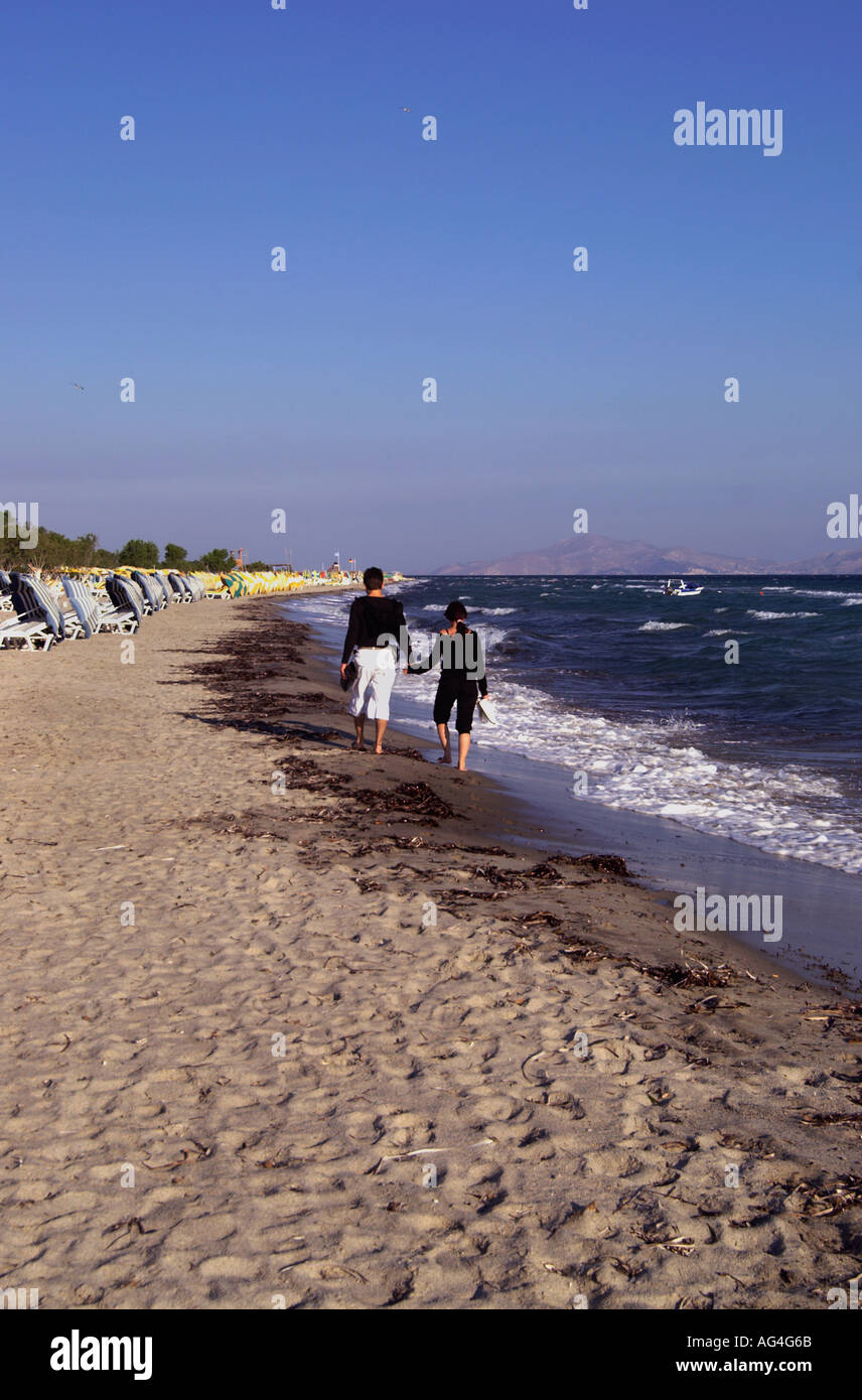 Young couple taking an early morning romantic stroll along Tingaki ...