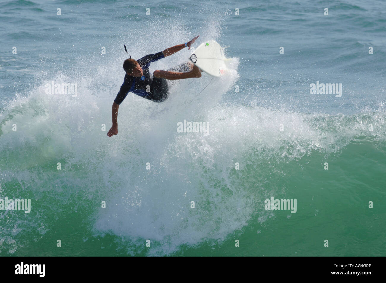 A surfer performing an aerial maneuver on waves in huntington beach ...