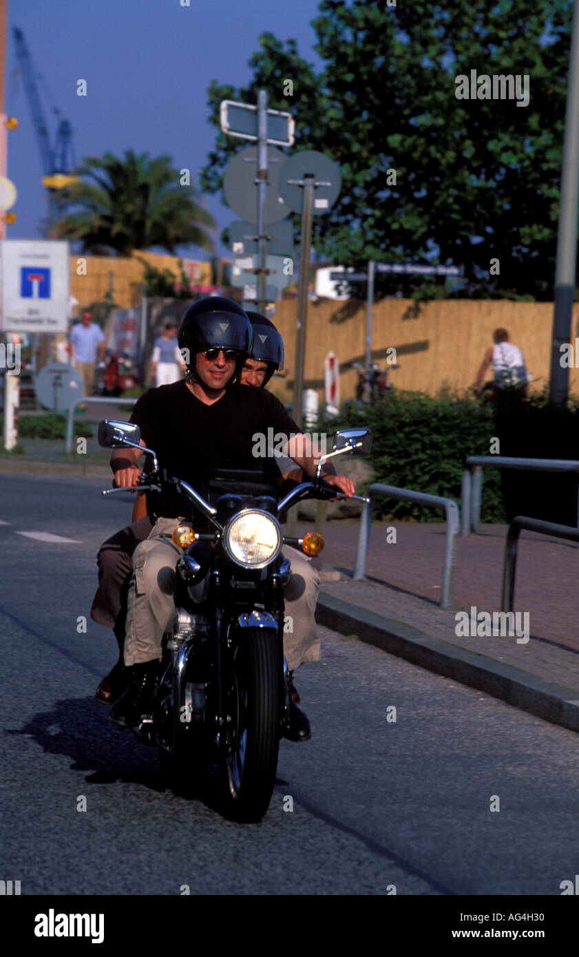 Germany Hamburg young people riding a motorcycle in the trendy area of ...