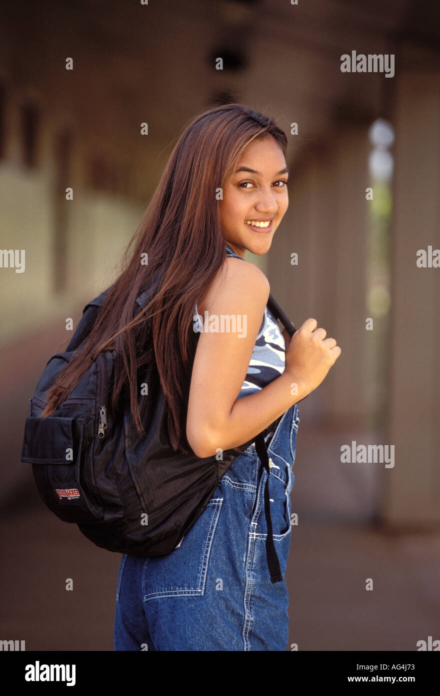Female student with backpack looks over her shoulder at Kihei, Maui ...