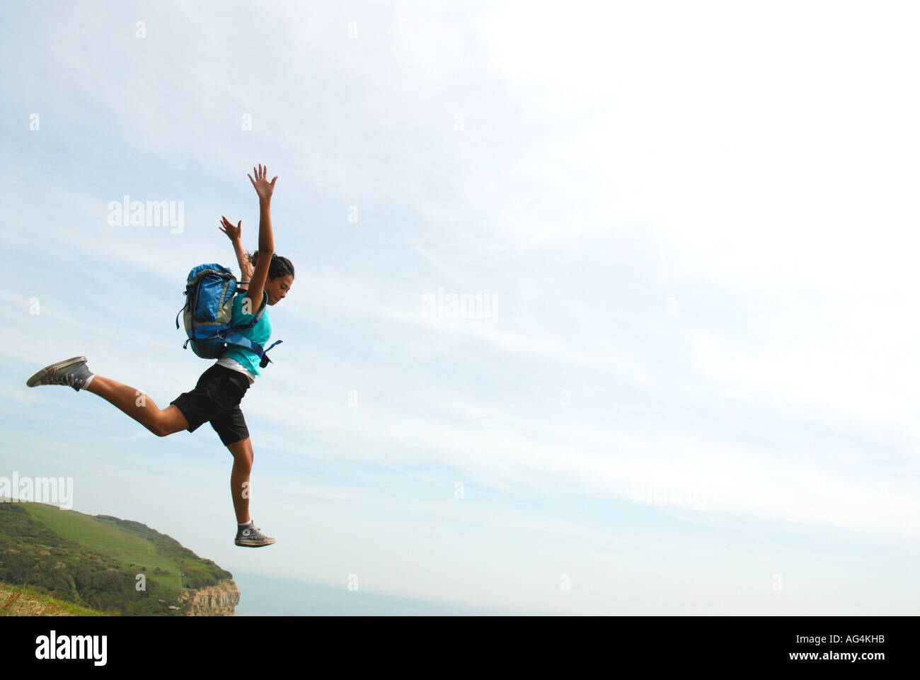Young girl seemingly leaping off a cliff Sarah Klein with backpack ...