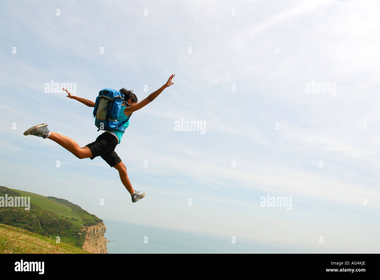 Young girl seemingly leaping off a cliff Sarah Klein with backpack ...