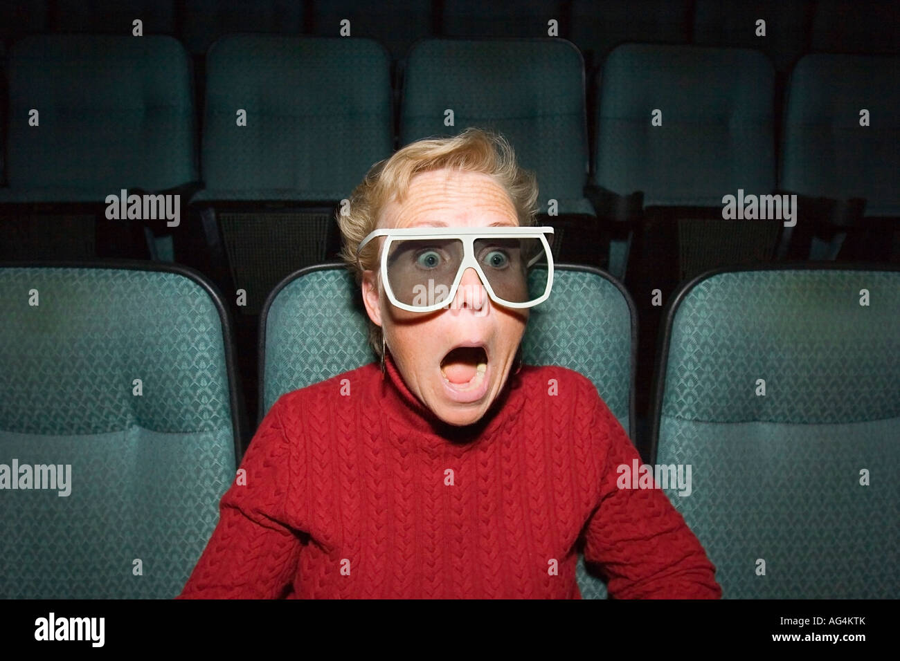 Woman with a shocked expression at a movie theater Stock Photo - Alamy