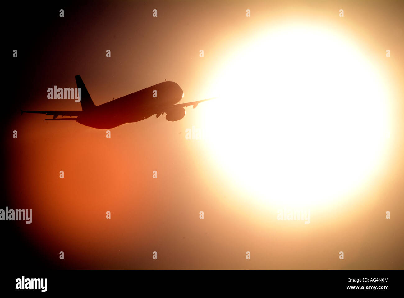 Airliner flying into sun Stock Photo - Alamy