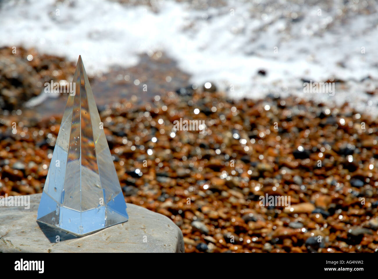 Glass pyramid on seashore beach waves rock pebbles Stock Photo - Alamy