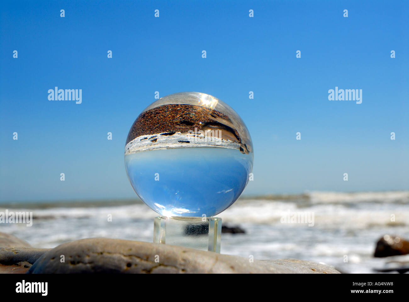 Glass ball crystal ball on seashore beach waves rock pebbles sea sky ...