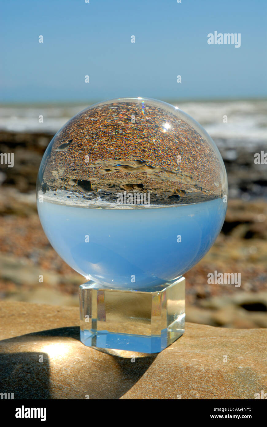 Glass ball crystal ball on seashore beach waves rock pebbles sea sky ...
