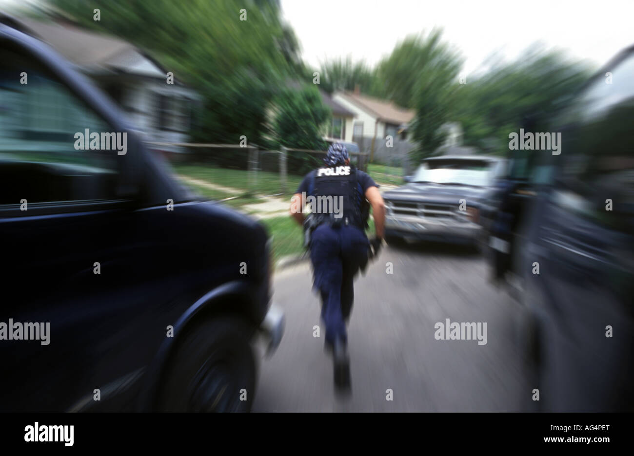 A cop runs towards a crack house being raided by Detroit narcs Stock ...