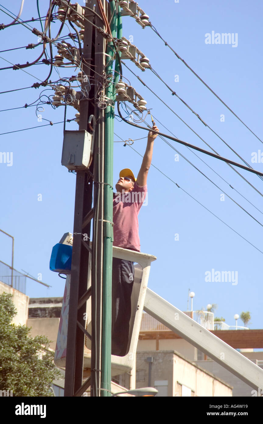 A hoisted technician fixing electric power wires Stock Photo - Alamy