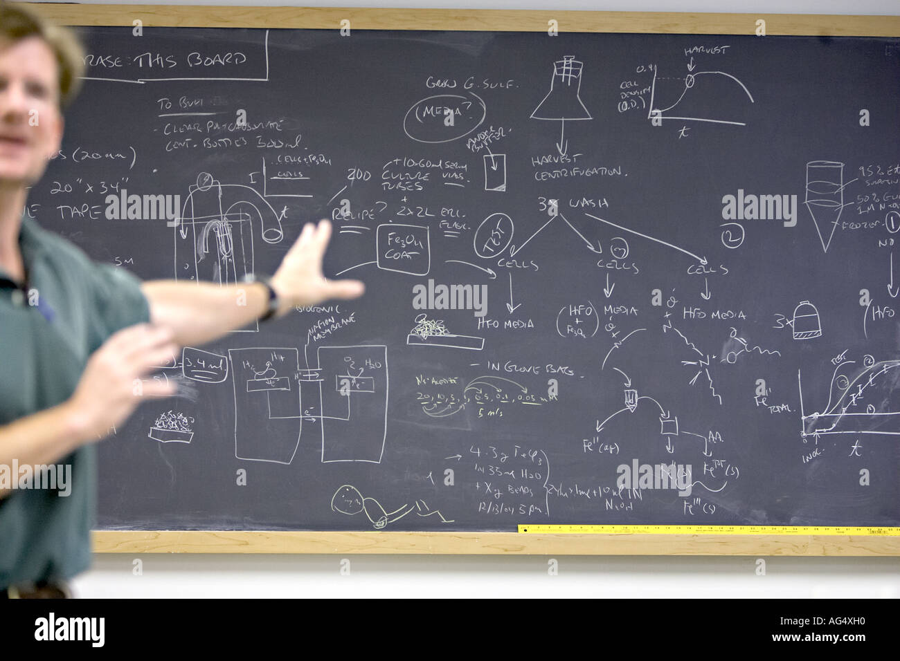 Male Science professor presenting information at blackboard edification ...