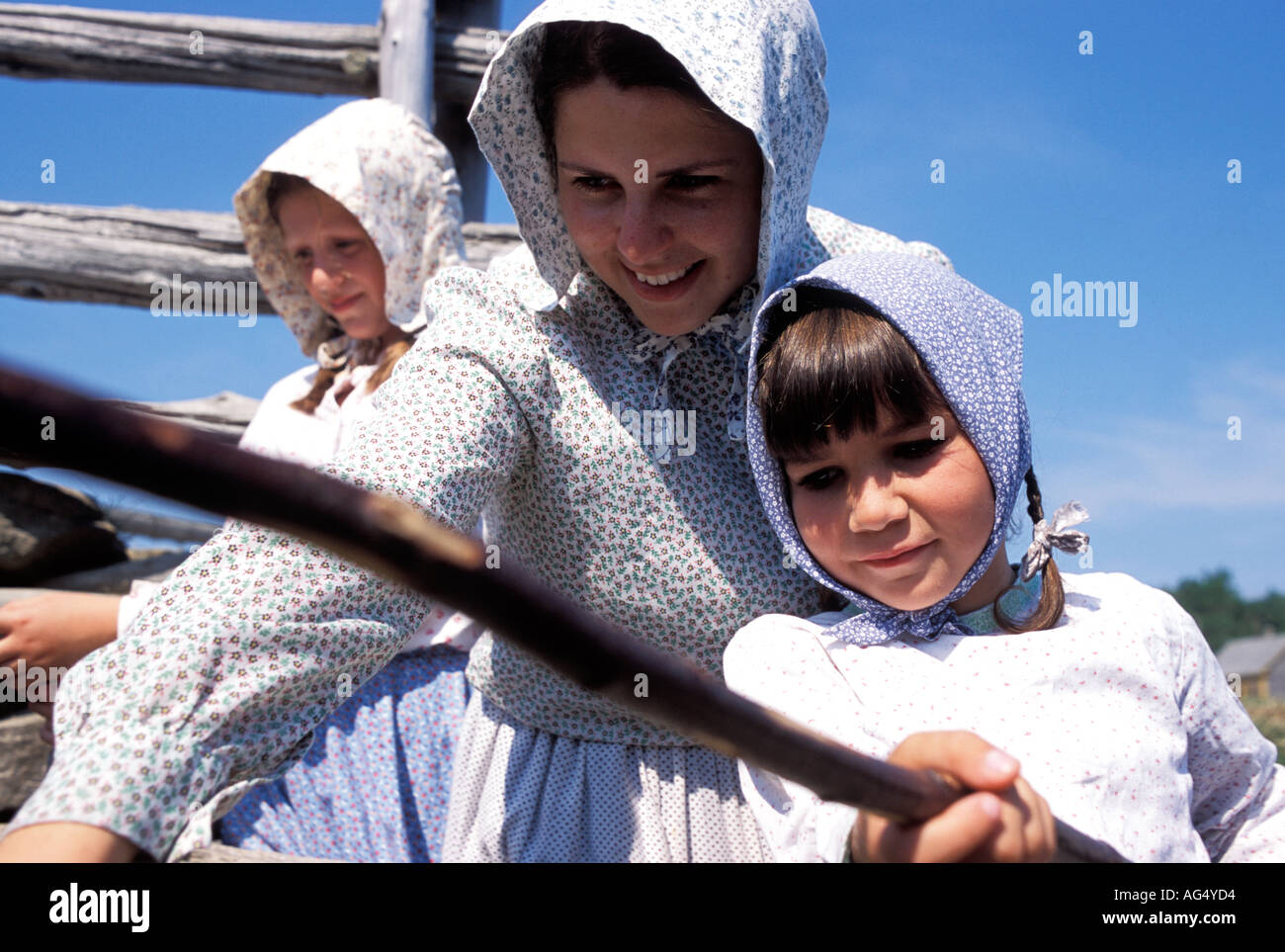 Two young girls and a young woman dressed up in period costumes of the ...