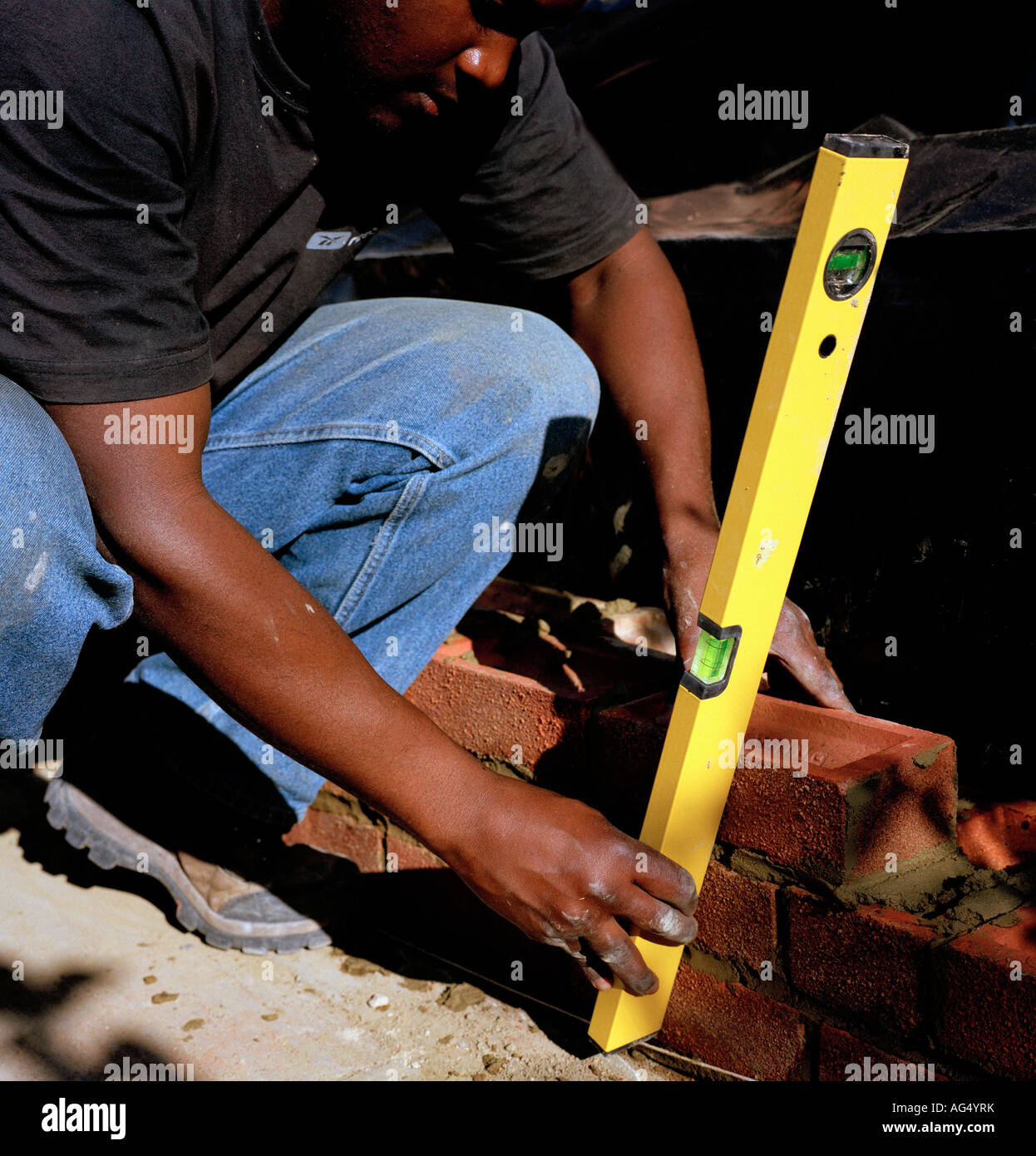 Man building a wall, checking it's level Stock Photo - Alamy